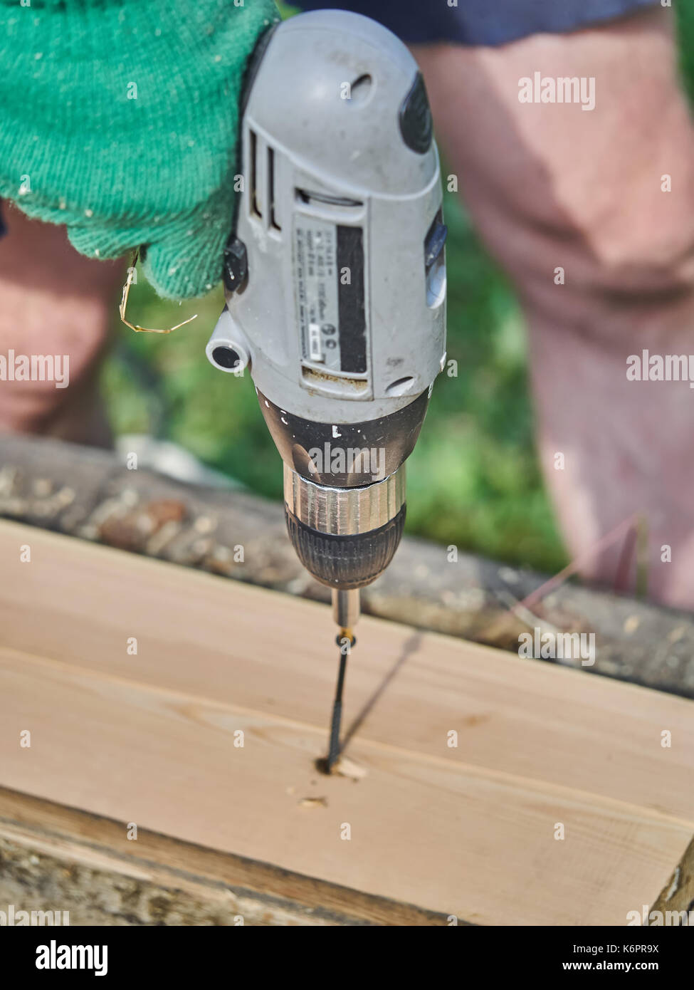 The builder screws the screw into the board Stock Photo - Alamy
