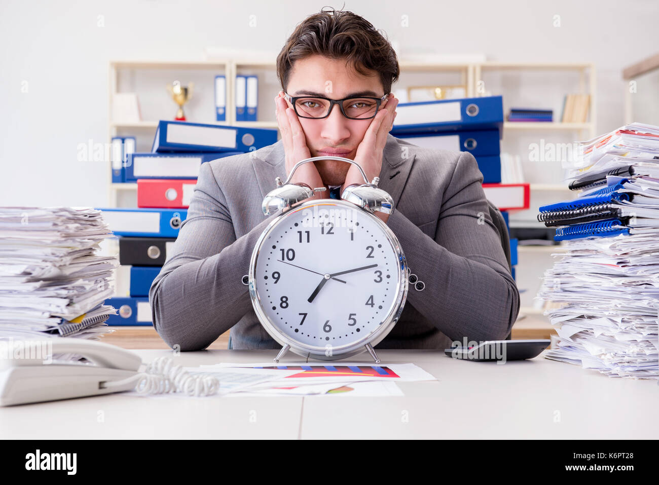 Businessman missing deadlines due to excessive work Stock Photo - Alamy