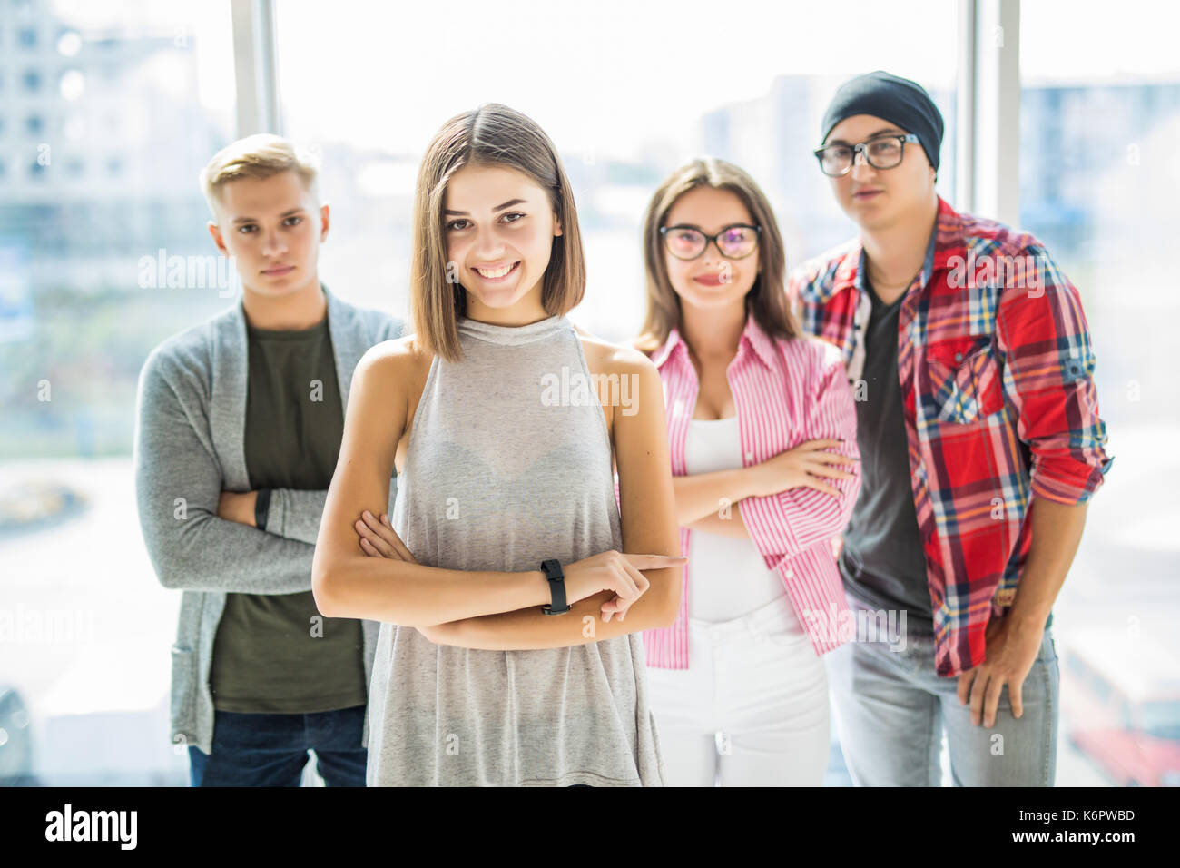 Successful team leader with a warm friendly smile standing with folded ...