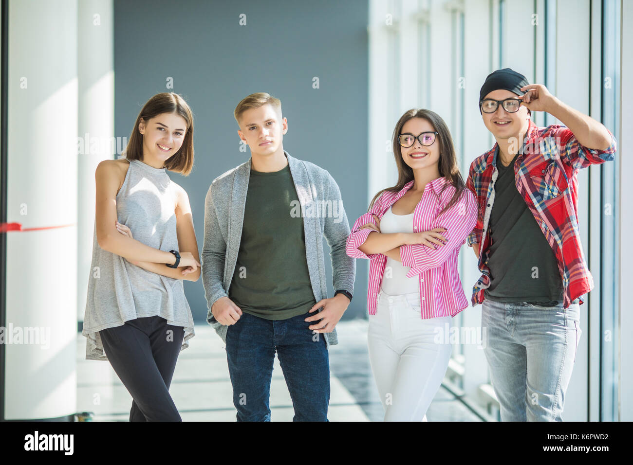Four friends standing and smiling. Four friends standing. Fours ...
