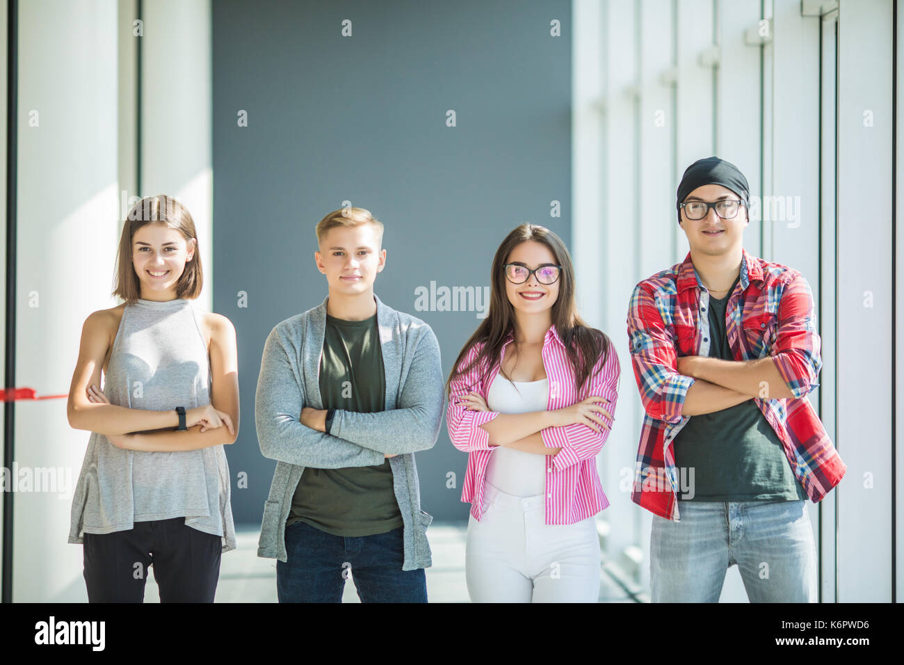 Four friends standing and smiling. Four friends standing. Fours ...