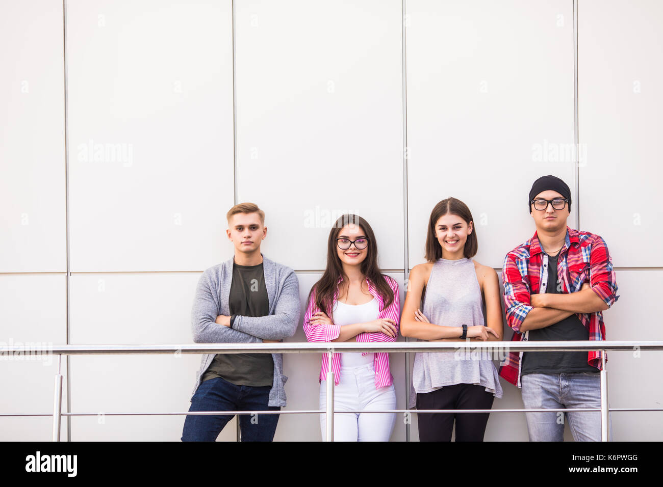 Group of four young smiling people wearing stylish casual clothing ...