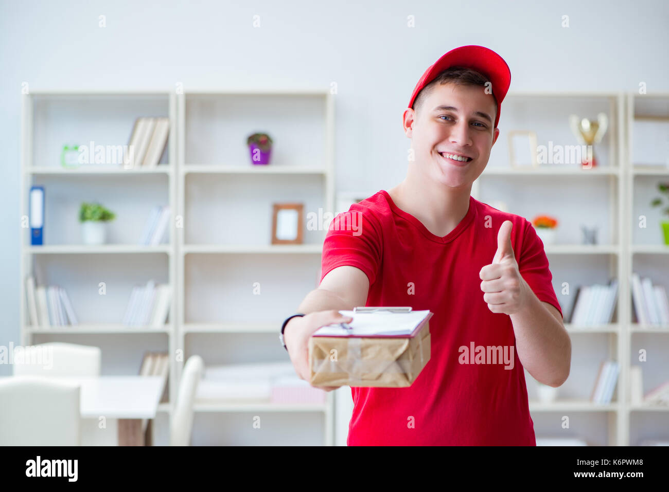 Post man delivering a parcel package Stock Photo - Alamy