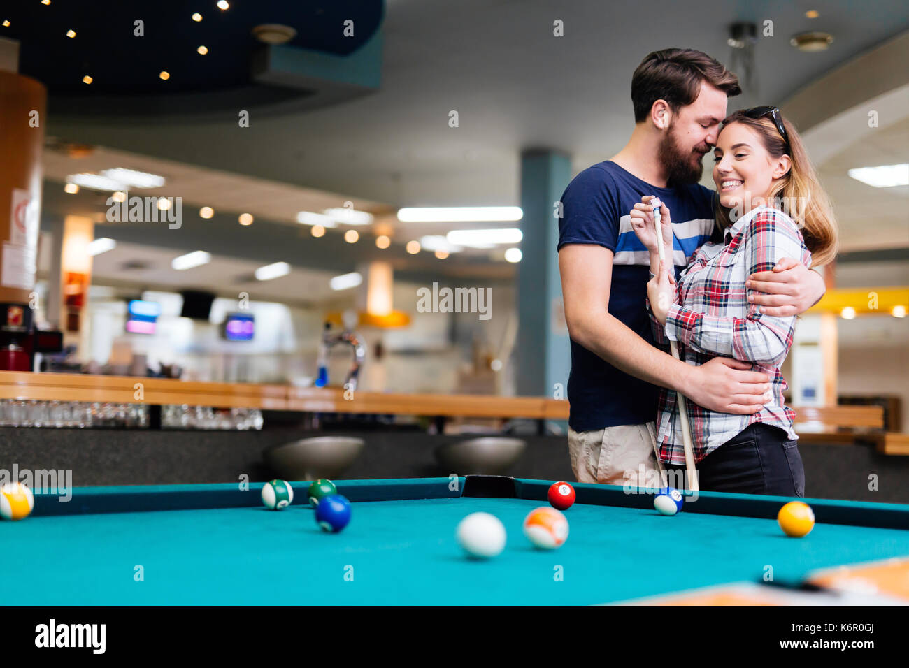 Beautiful couple playing billiards Stock Photo - Alamy