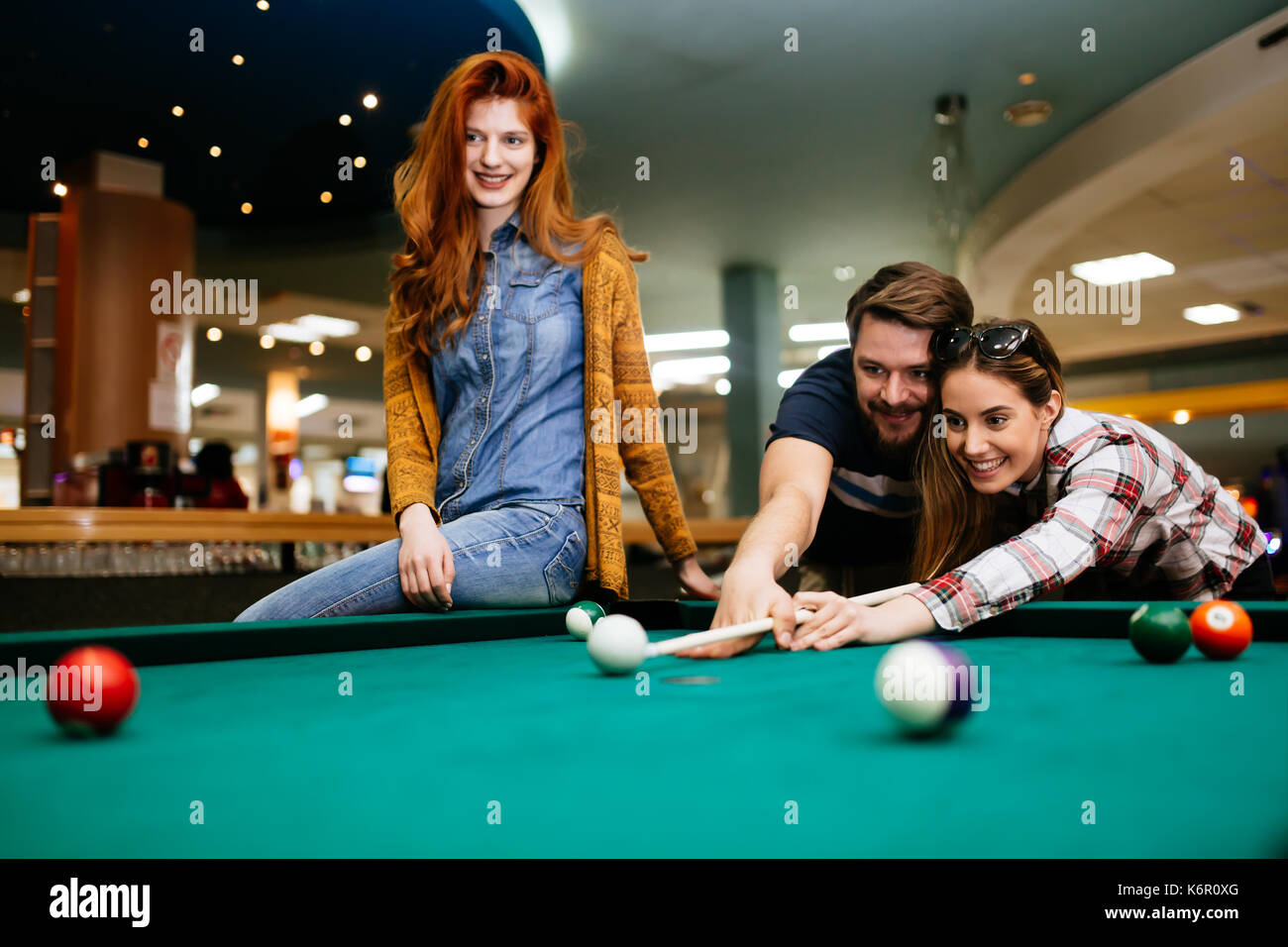 Happy friends enjoying playing pool Stock Photo - Alamy