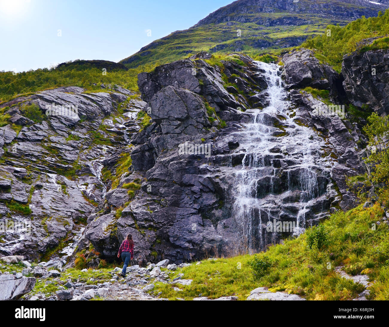 Hjorundfjord, Norway - October 2nd, 2017: Girl hiking to a Waterfall in ...