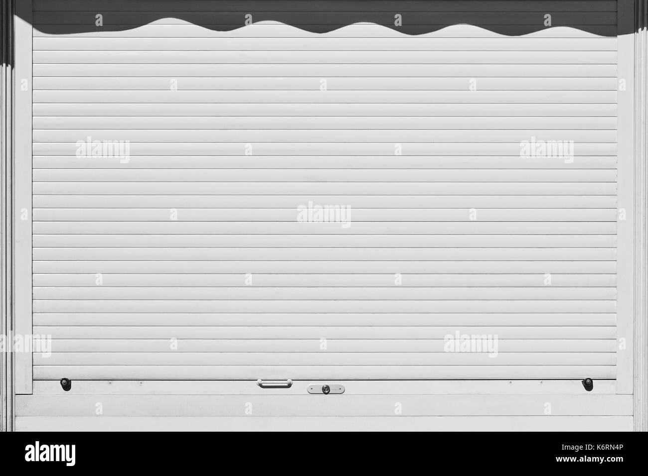 Closed and locked white rolling shutter. Security background ...