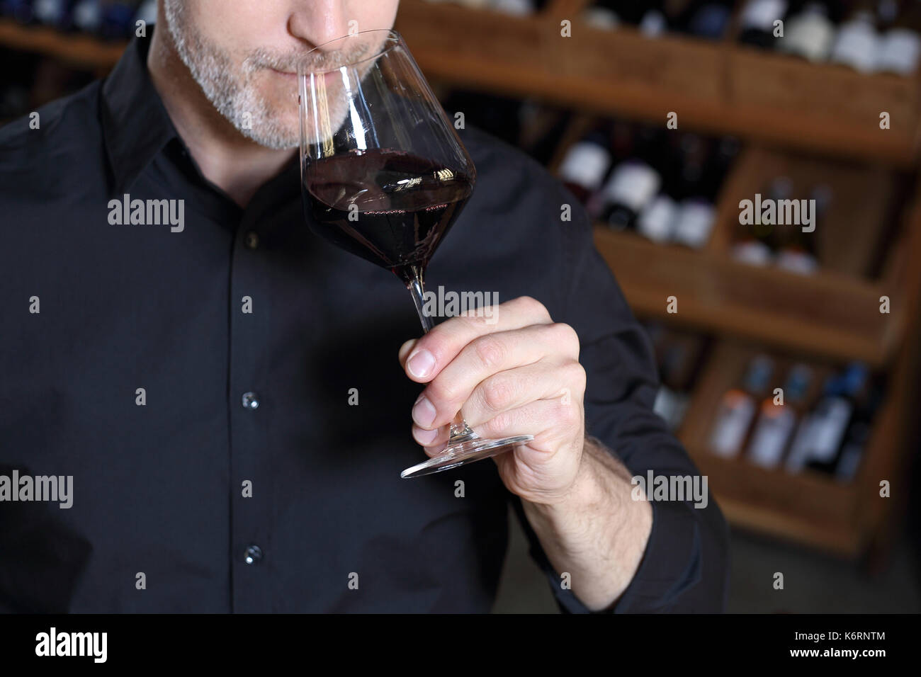 A handsome man judges the color of red wine Stock Photo - Alamy