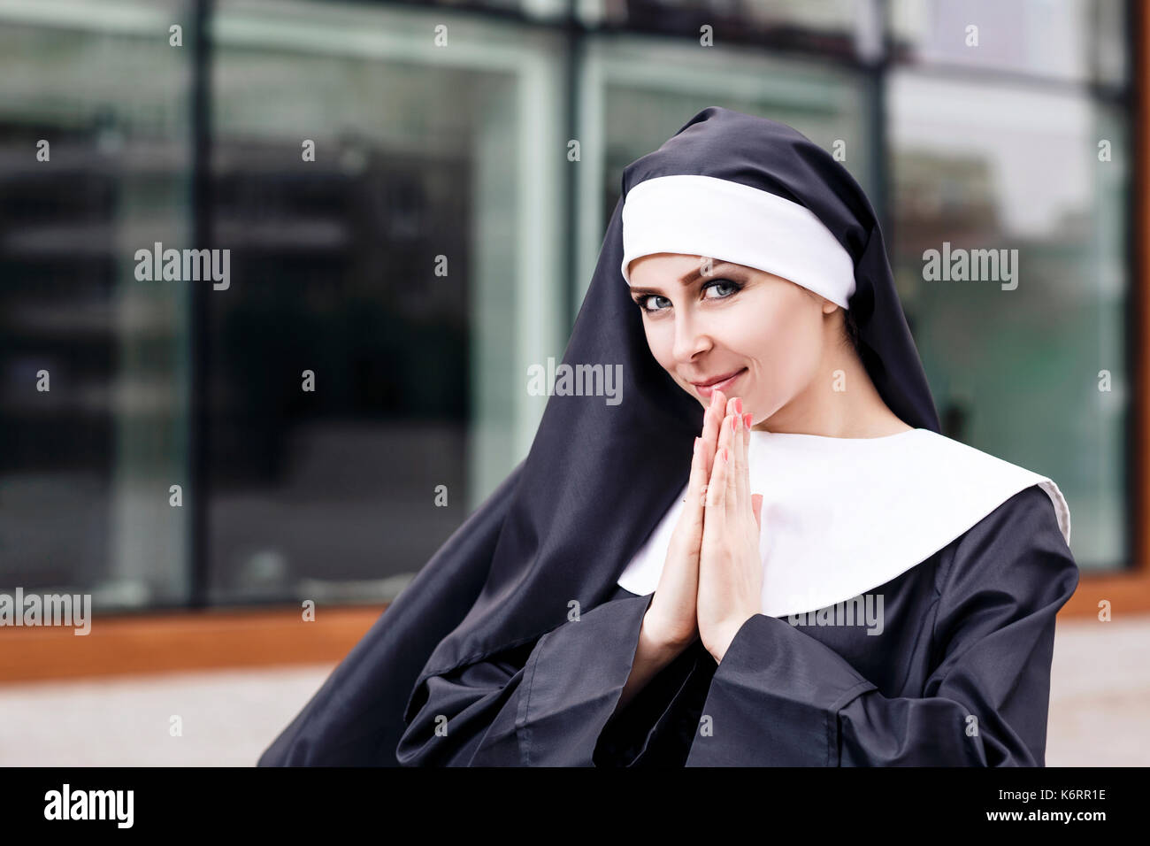 Young nun with bright makeup praying outdoors Stock Photo - Alamy