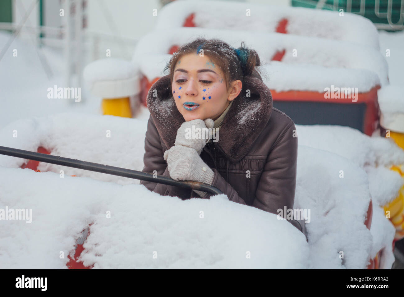Winter portrait of a girl with bright make up and blue stars on face ...