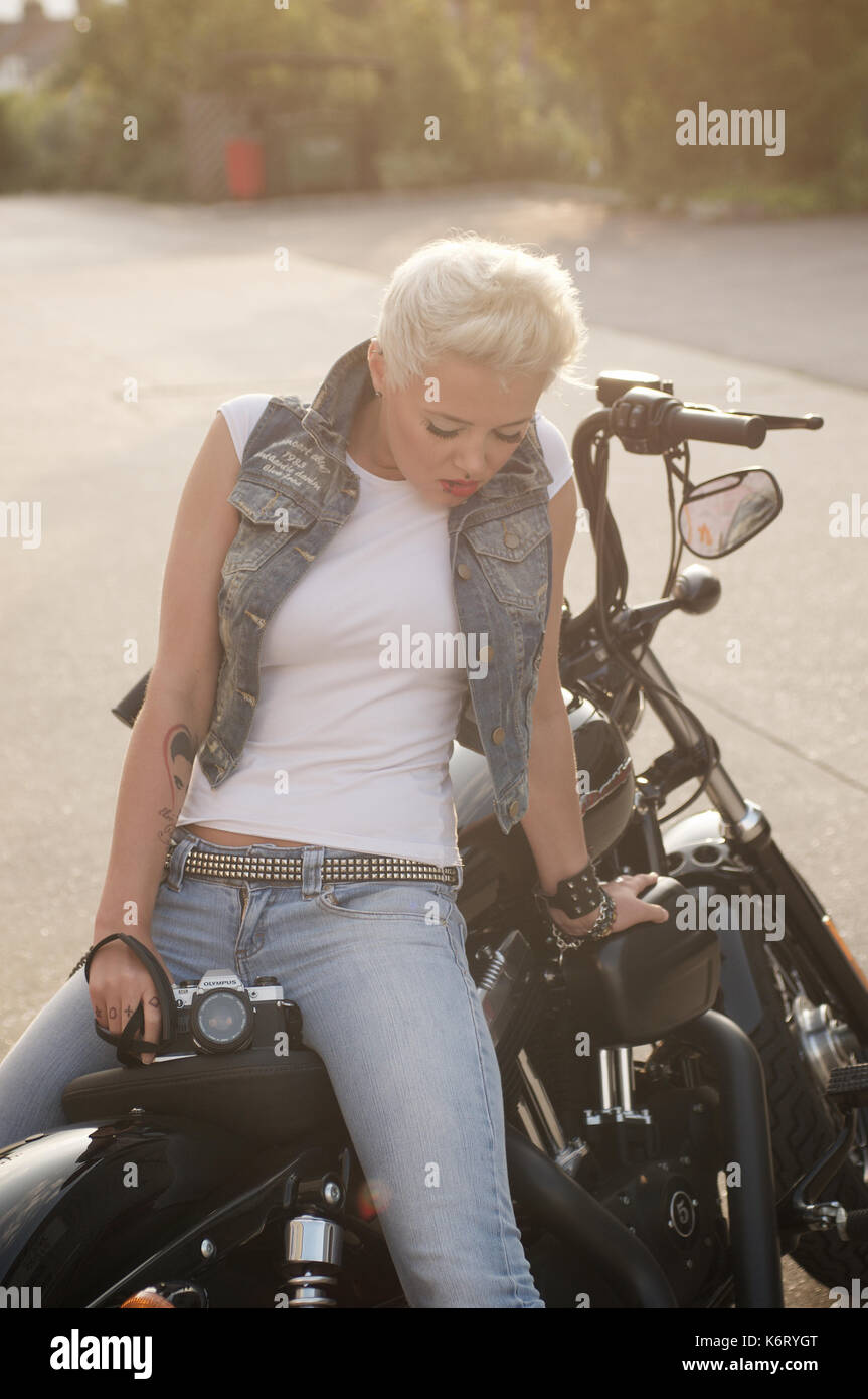 Beautiful short-haired blonde girl with a Harley Davidson motorcycle ...