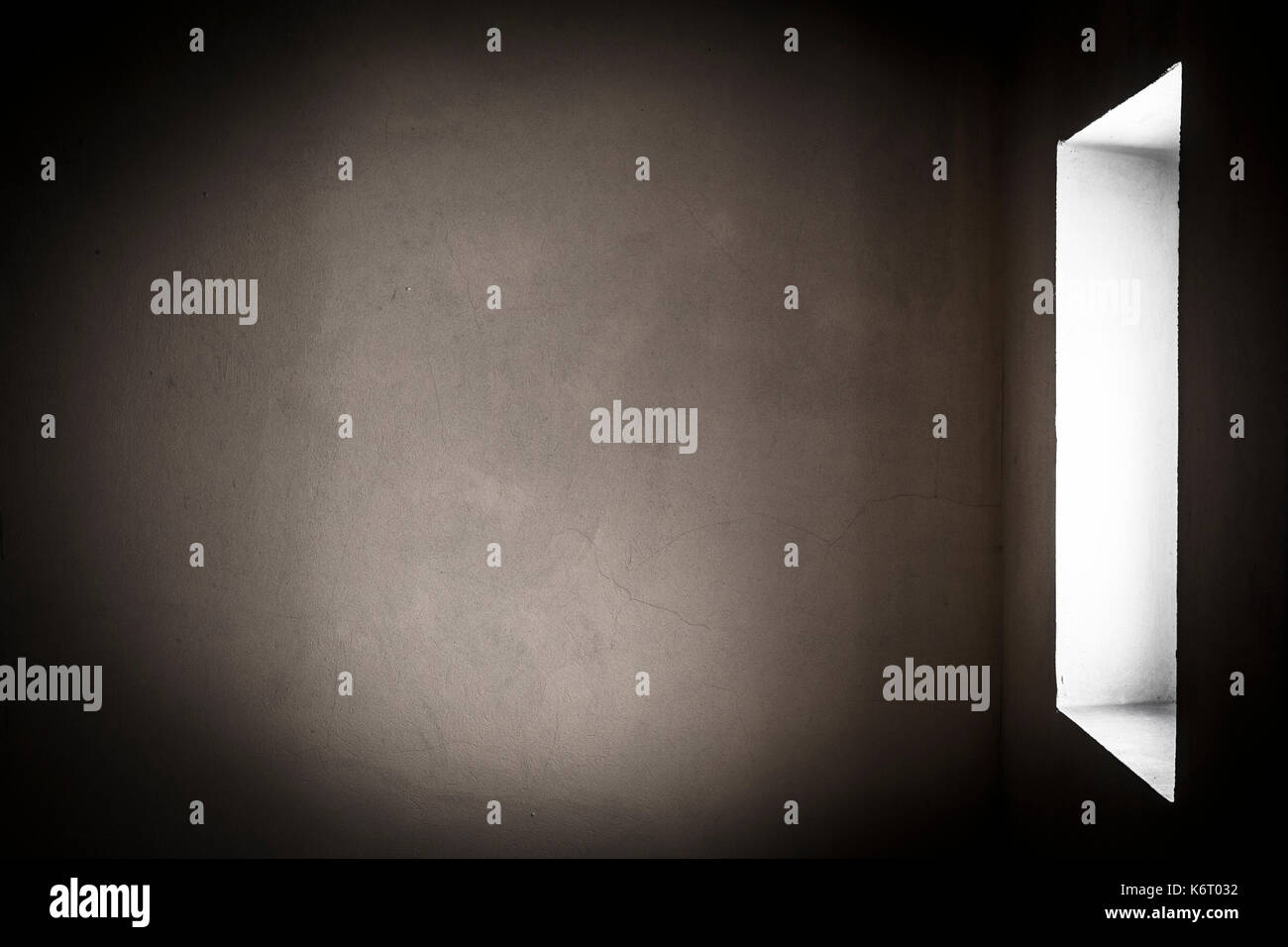 Light from the window in a dark, cold room with concrete walls Stock ...