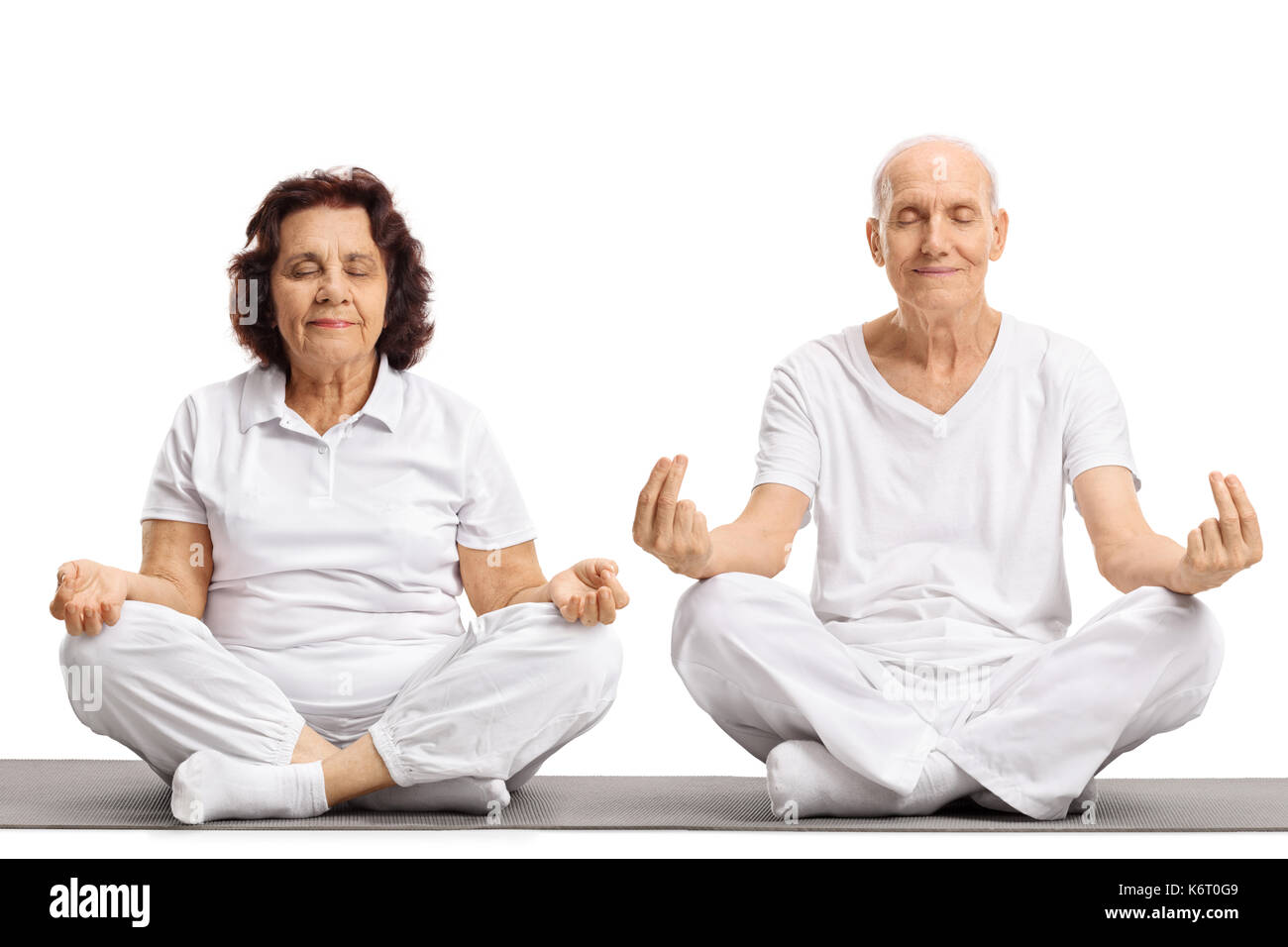 Seniors meditating on an exercise mat isolated on white background ...