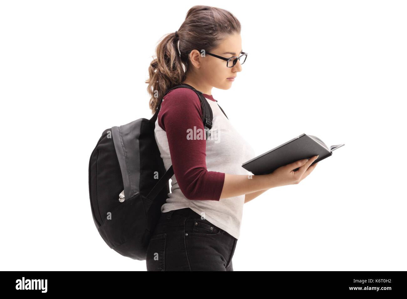 Female student with a backpack reading a book isolated on white ...