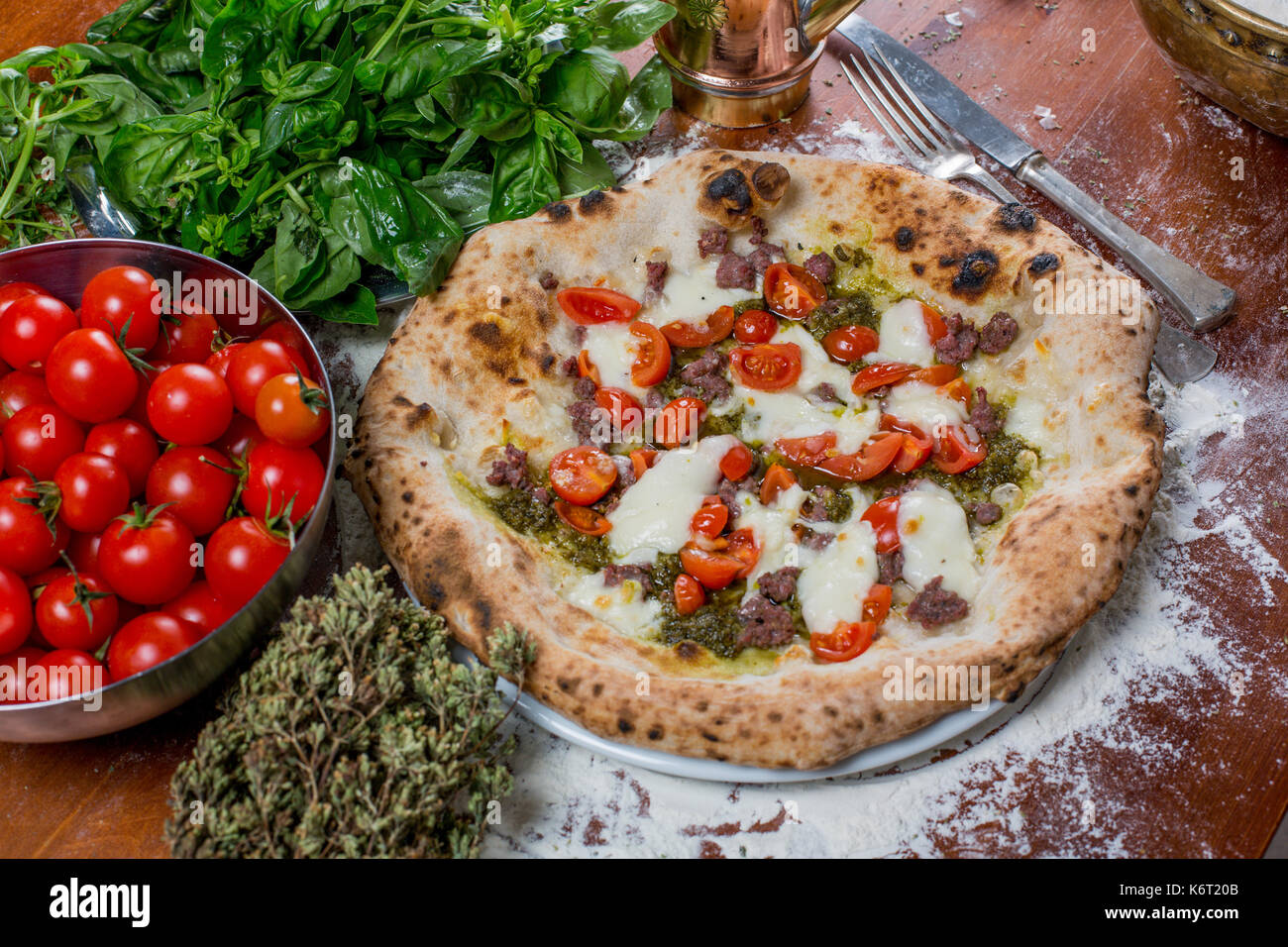Traditional italian pizza with mozzarella, sausage, tomato and pesto ...