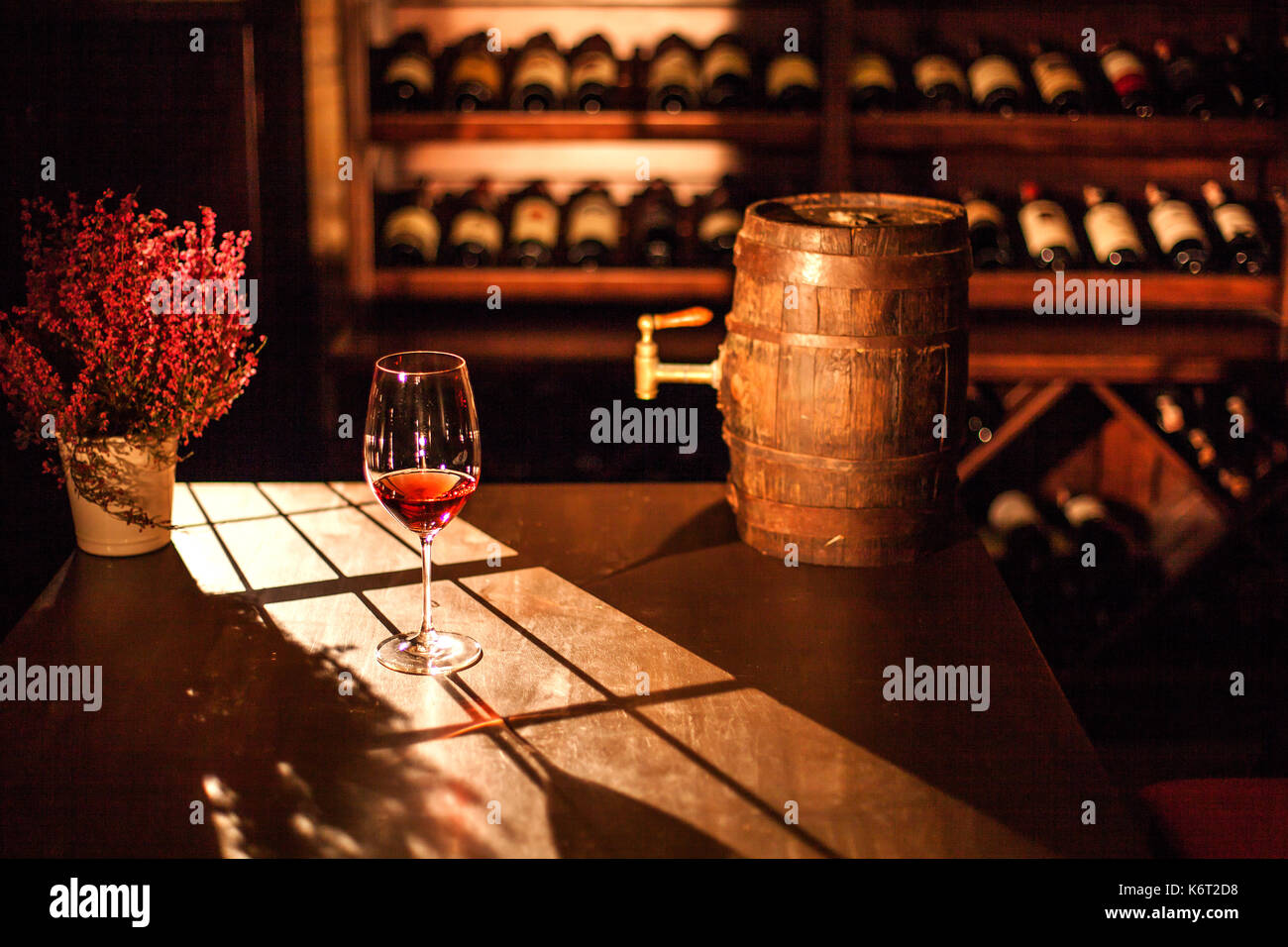 Composition of wine glass. wooden wine barrel and flowers placed on a ...