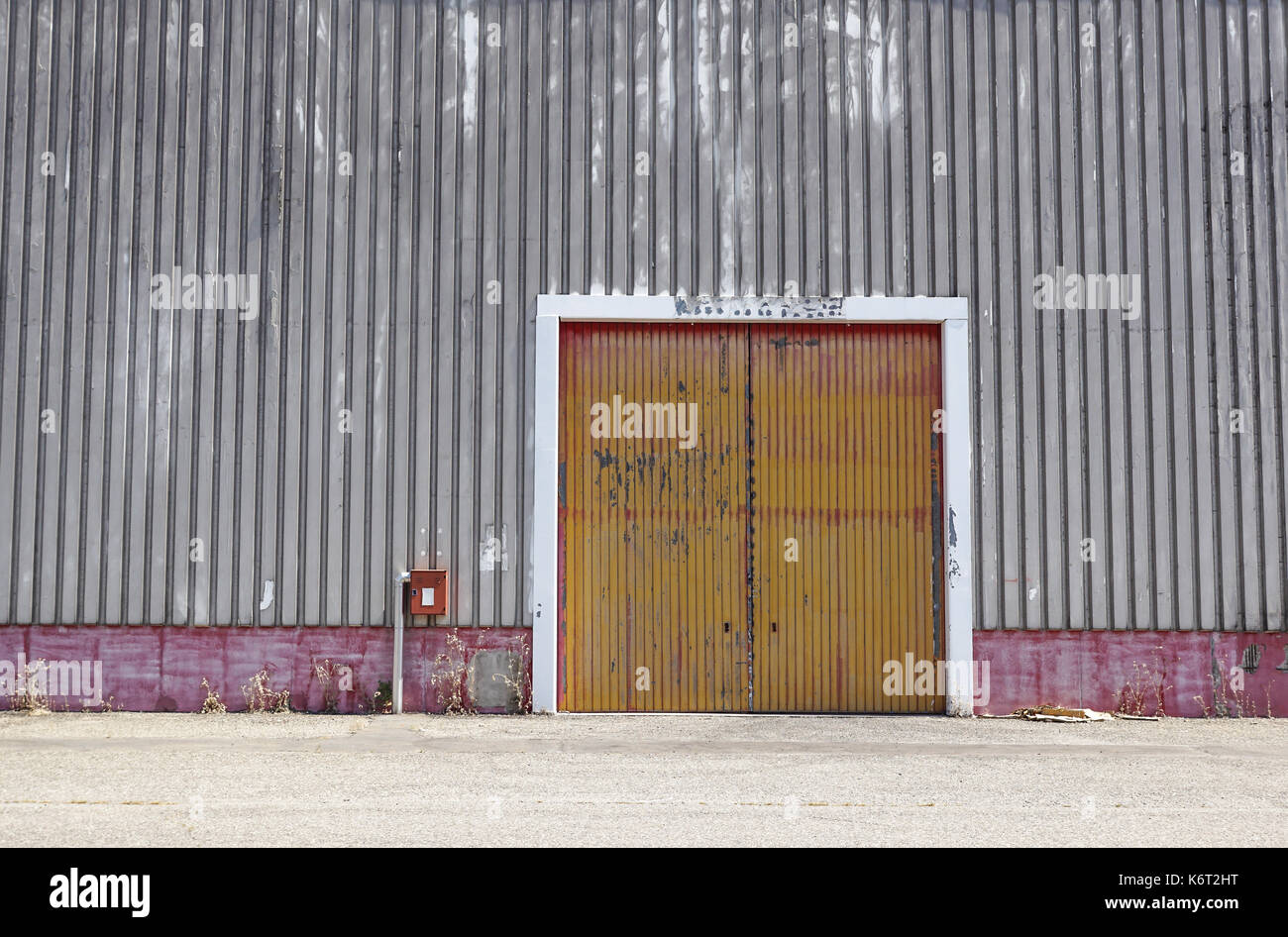 The sheet metal factory wall with the entrance door in the industrial ...