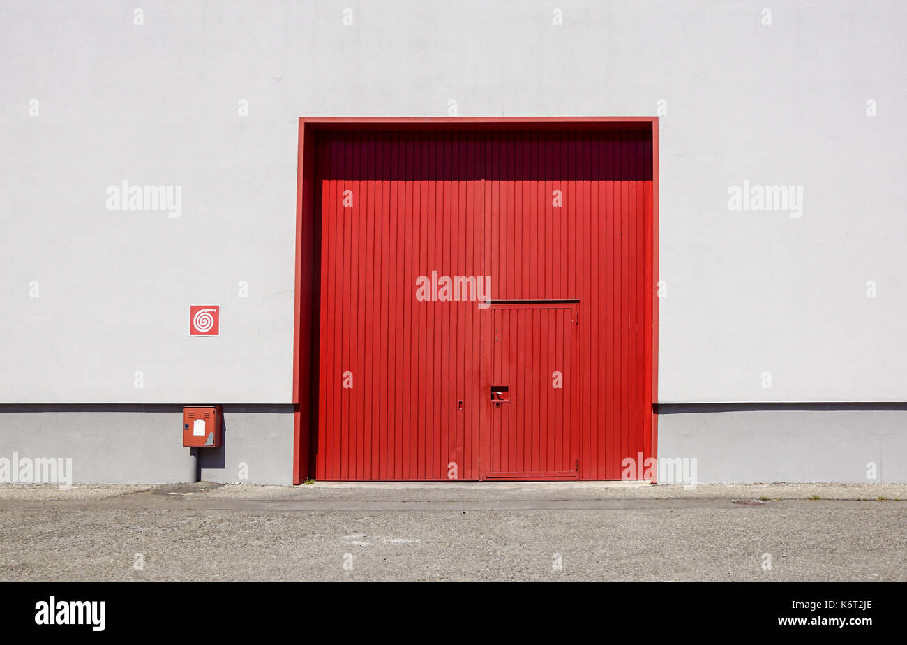 The sheet metal factory wall with the red entrance door in the ...