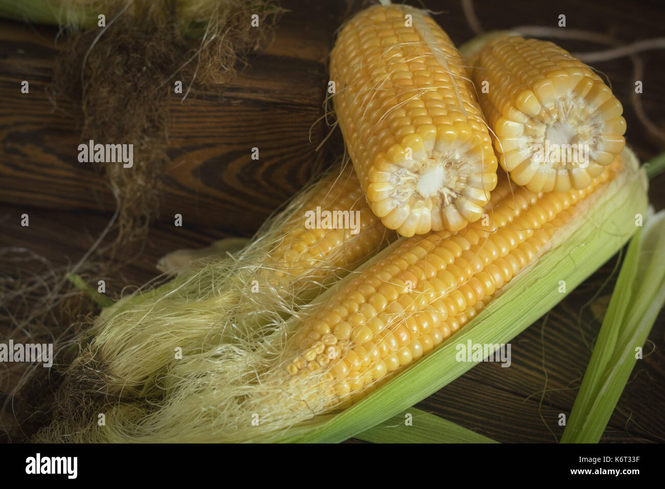 Fresh sweet corn on cobs on rustic wooden table, close up. Toned ...