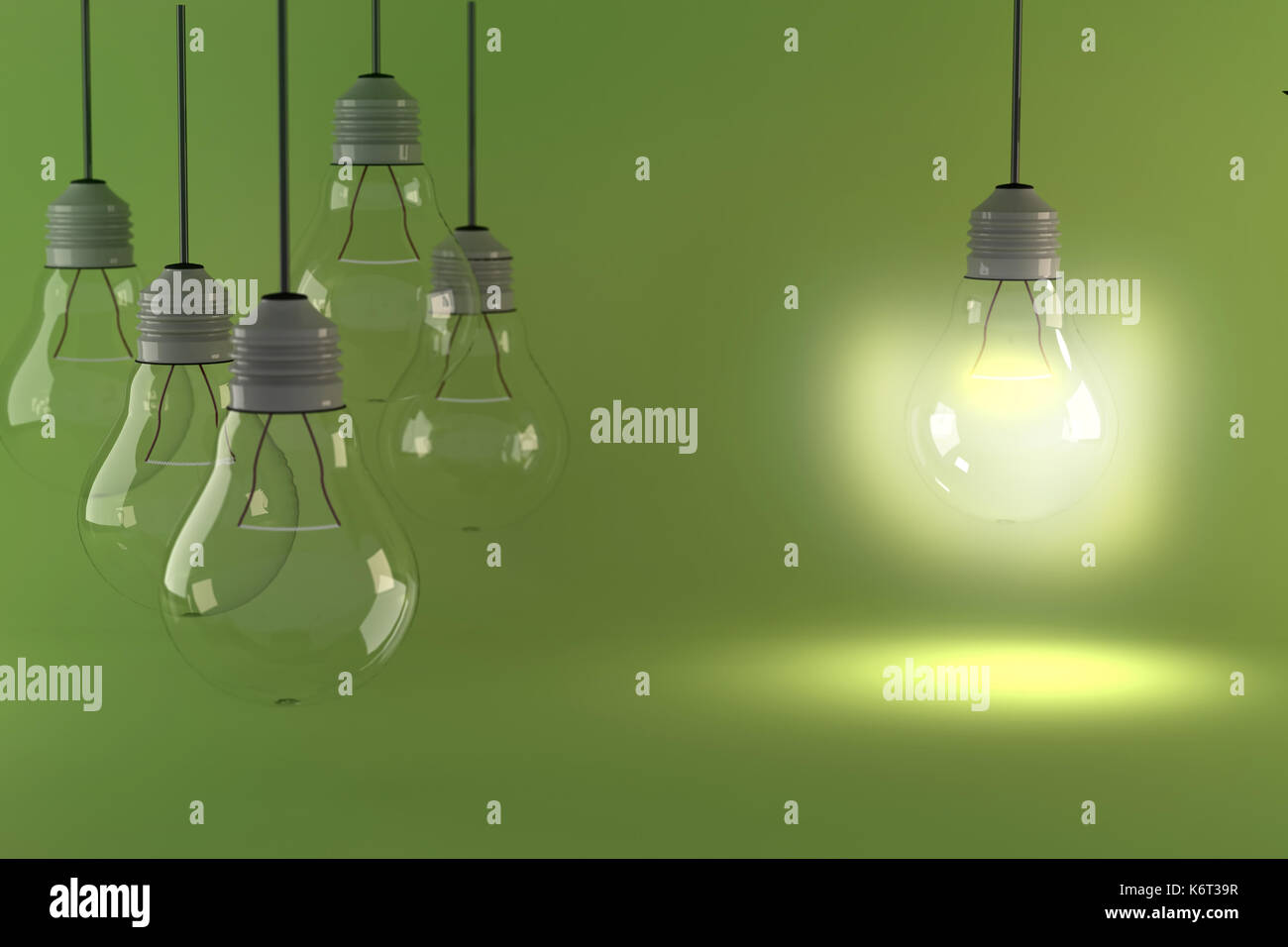 One hanging light bulb glowing different and standing out from unlit ...