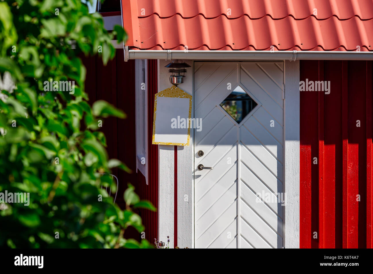 Empty note hanging beside door to a small red cabin or house Stock ...