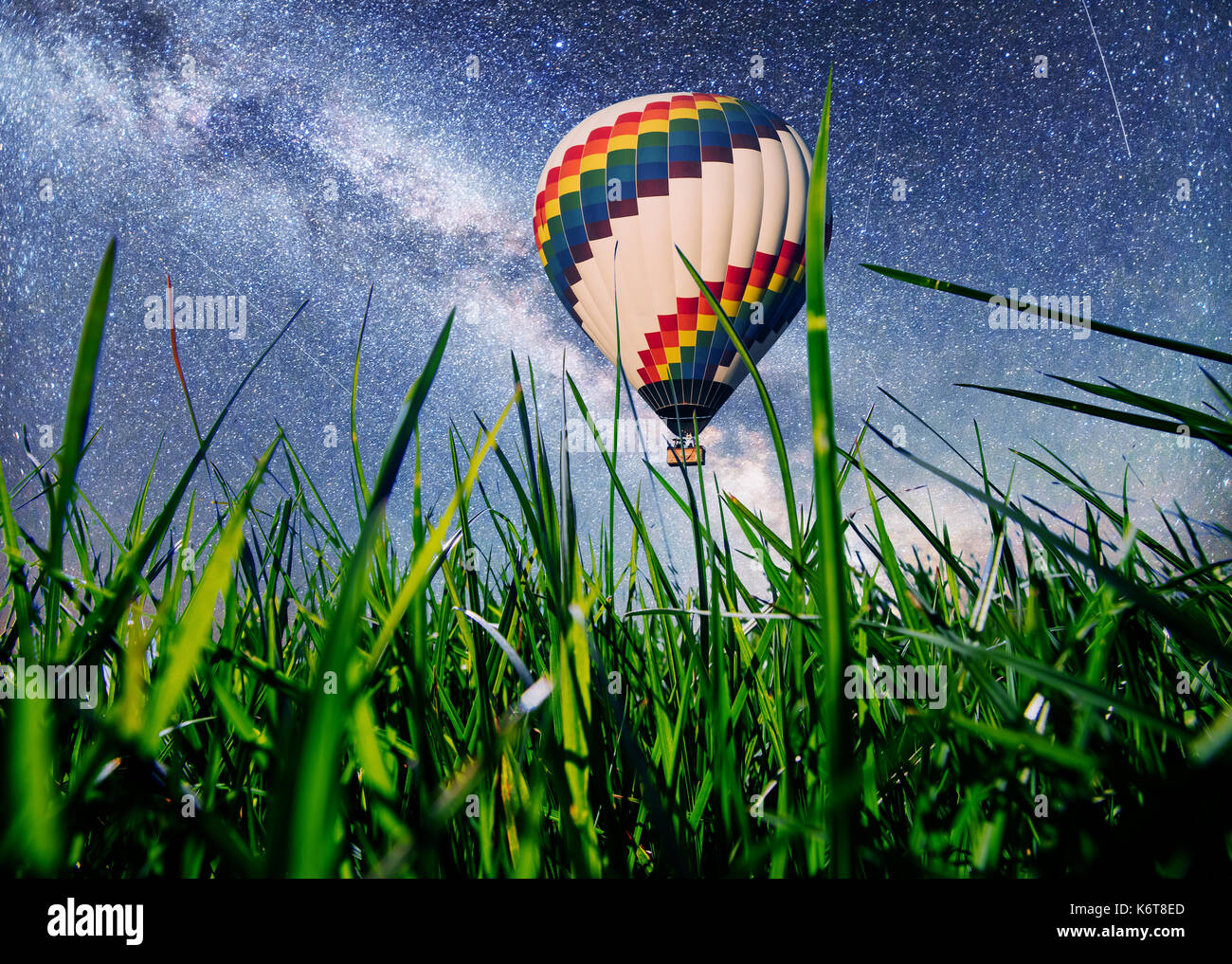 Fantastic starry sky and the milky way over spring grass and balloon ...