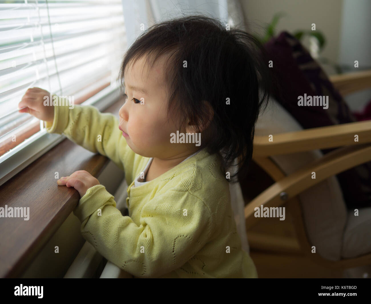 baby girl looking out windows Stock Photo - Alamy