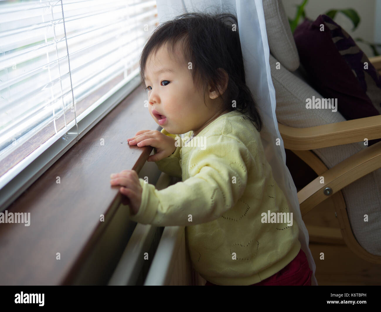 baby girl looking out windows Stock Photo - Alamy