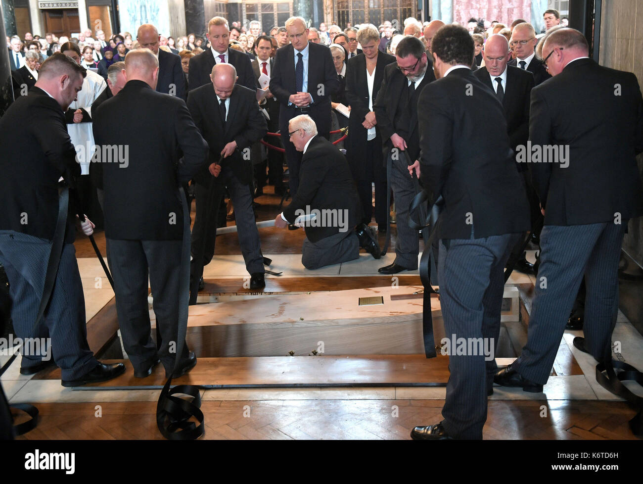 Family members watch the lowering of the coffin of Cardinal Cormac ...
