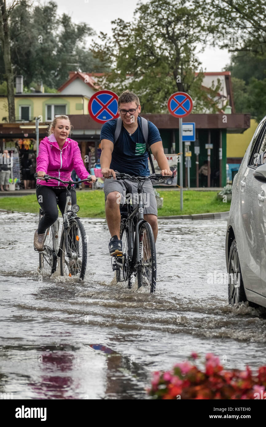 Sarbinowo, Poland - August 2017 : Young couple cycling in a deep water ...