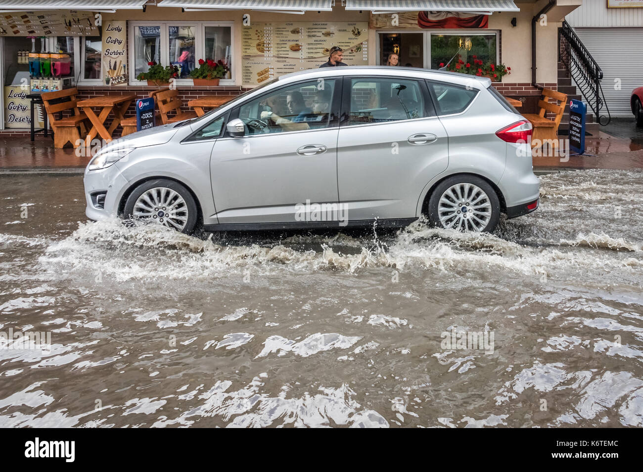 Sarbinowo, Poland - August 2017 : Car going through the flooded street ...