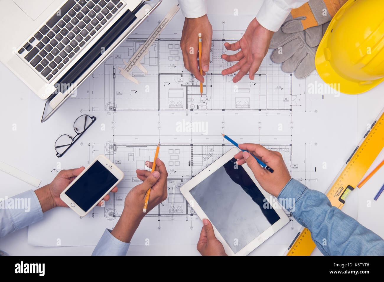 Hands of professional architects discussing and working with blueprints ...