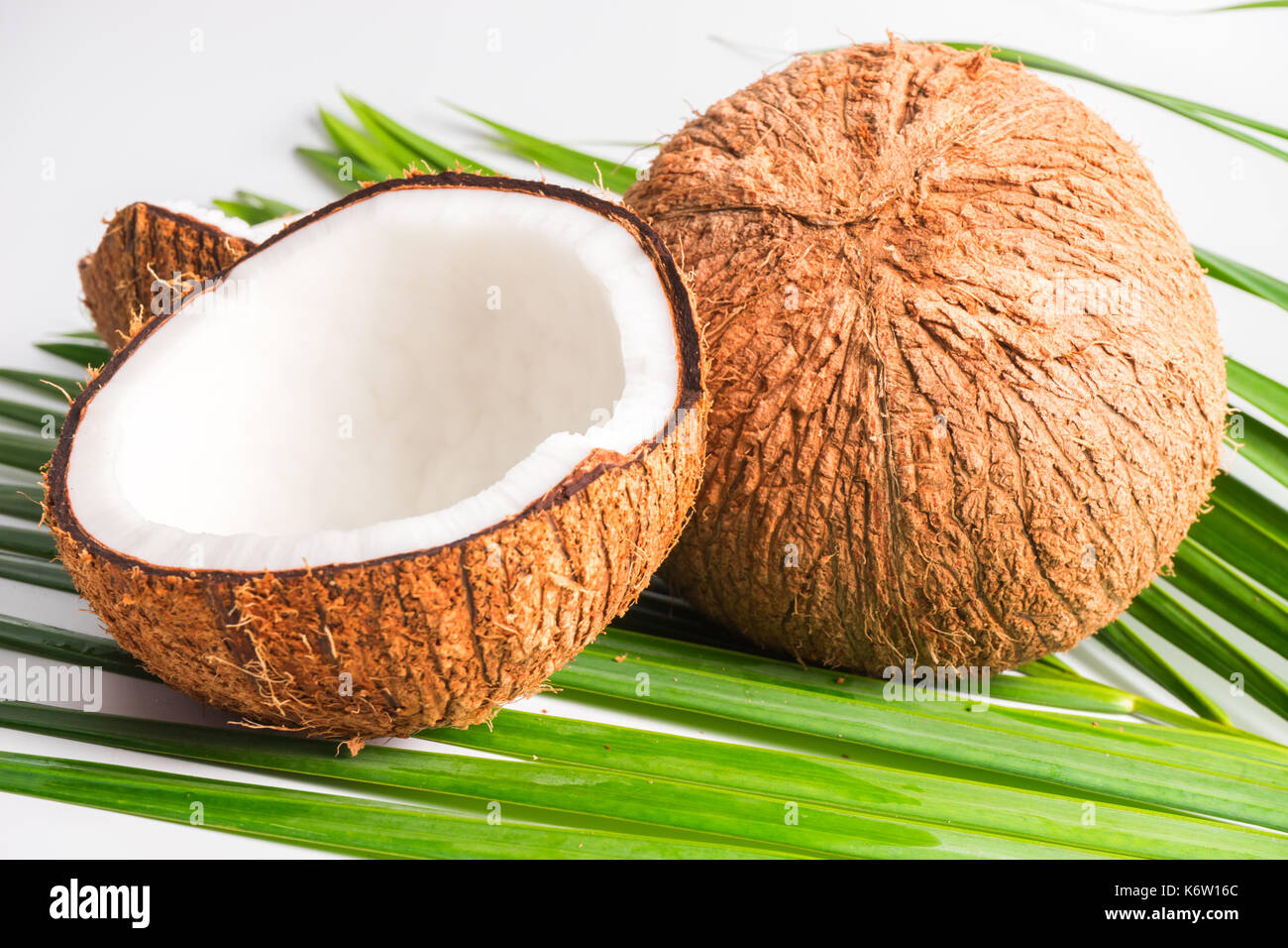 Coconut with half and leaves on white background Stock Photo - Alamy