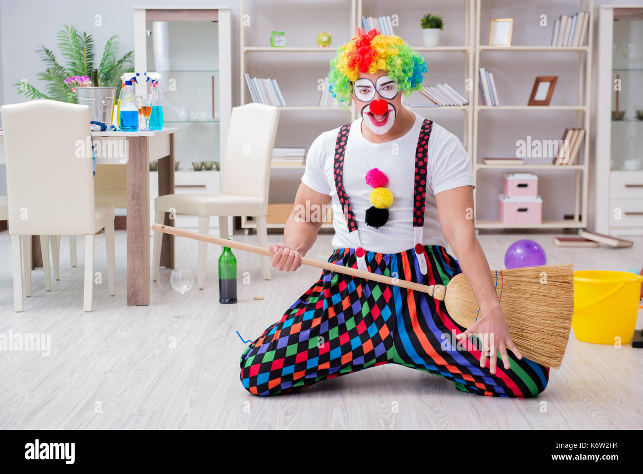 Funny clown doing cleaning at home Stock Photo - Alamy