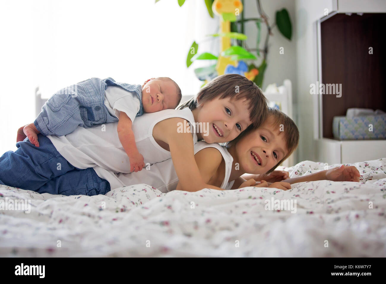 Two children, toddler and his big brother, hugging and kissing their ...