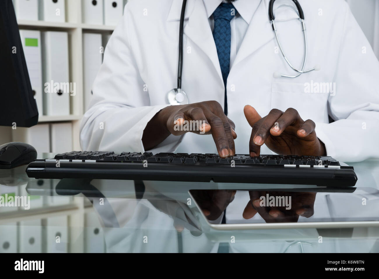Doctor typing computer hi-res stock photography and images - Alamy