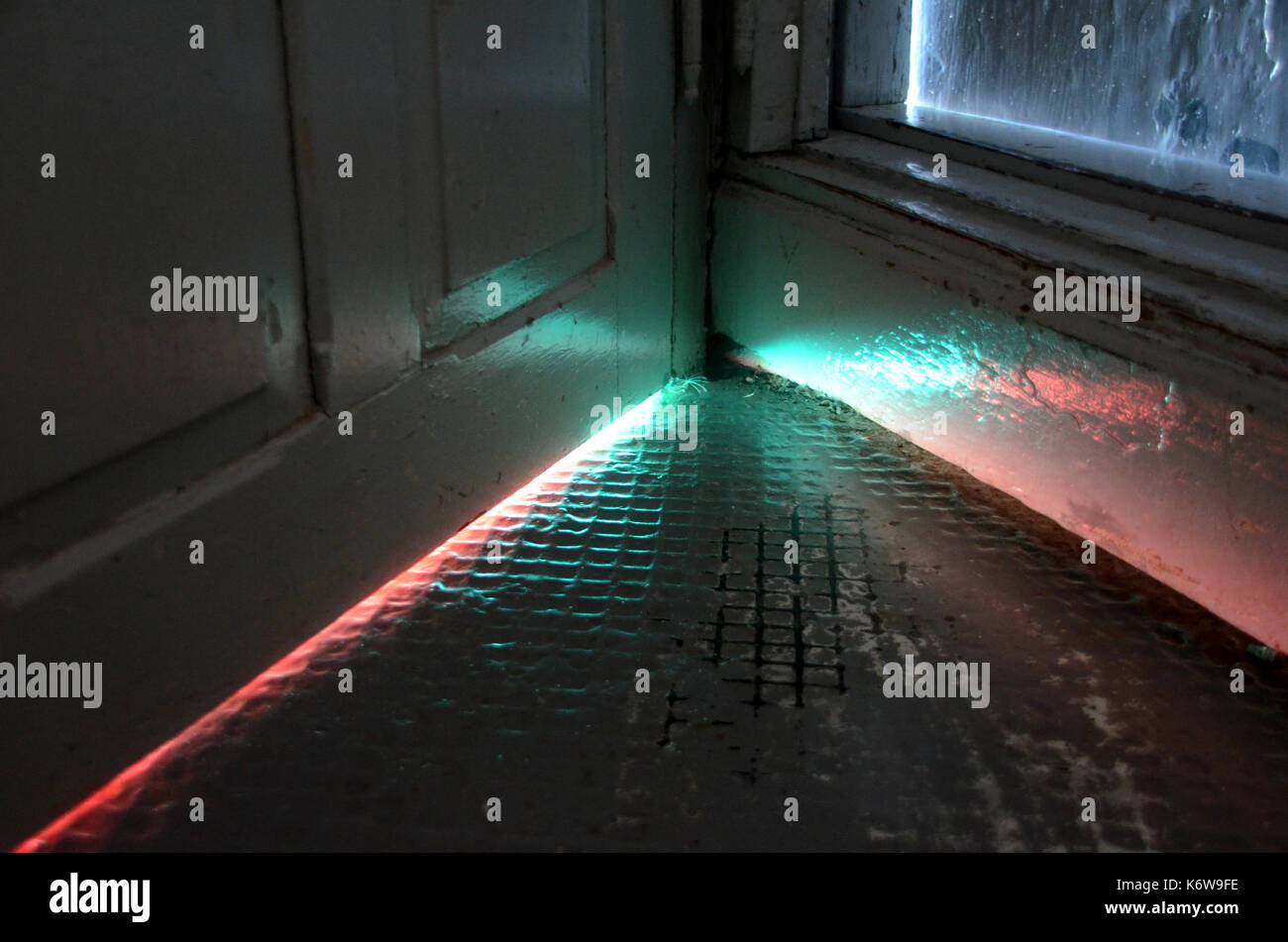 Light in strange colors seen coming from under a door Stock Photo - Alamy
