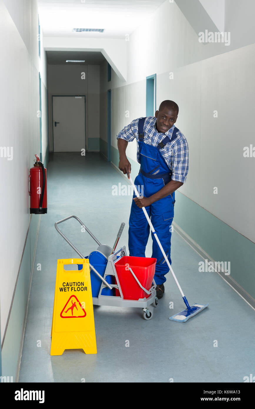 Portrait Of Young African Male Janitor Cleaning Floor In Corridor Stock ...