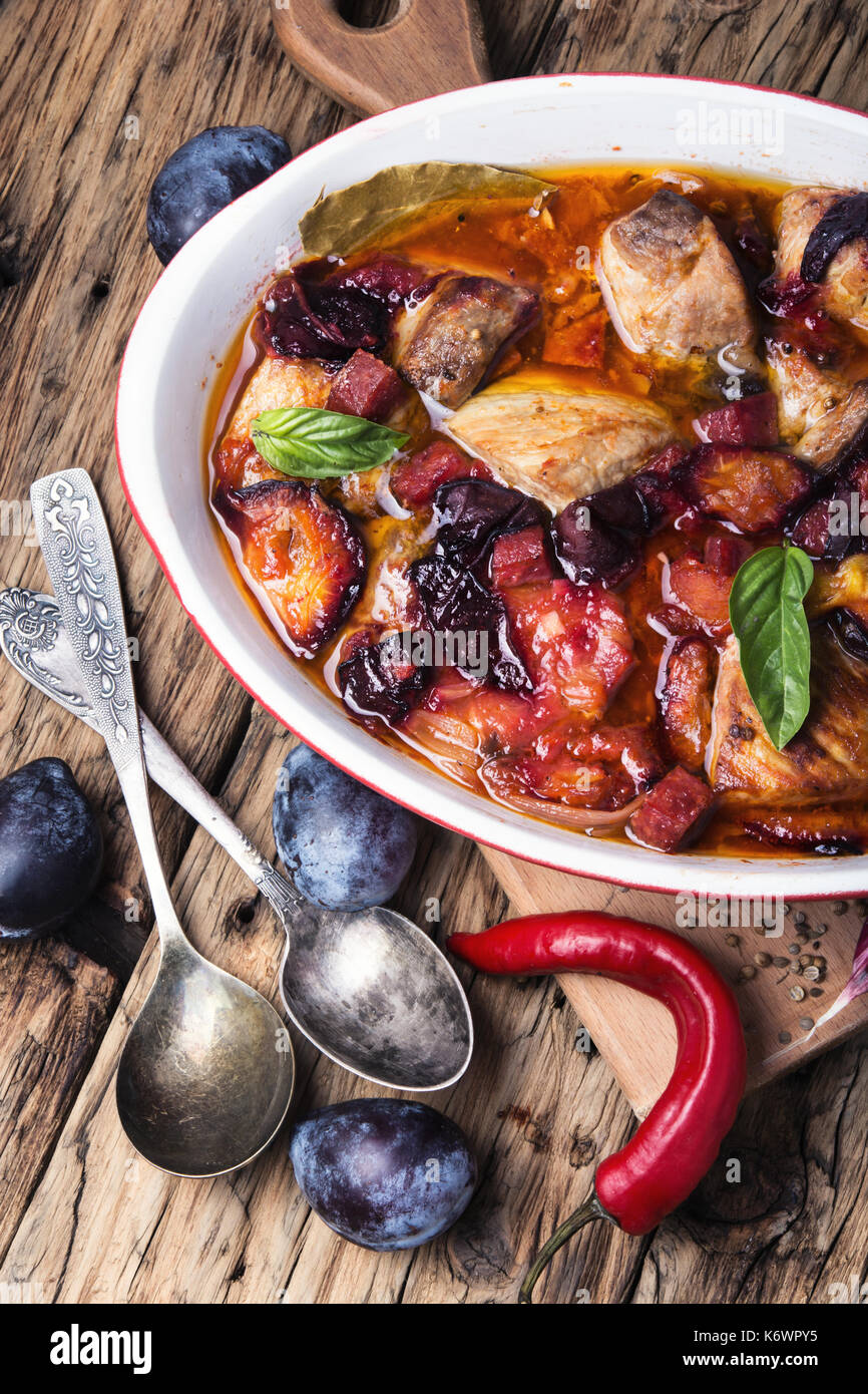 meat stew in sauce of autumn plums on a retro background Stock Photo ...