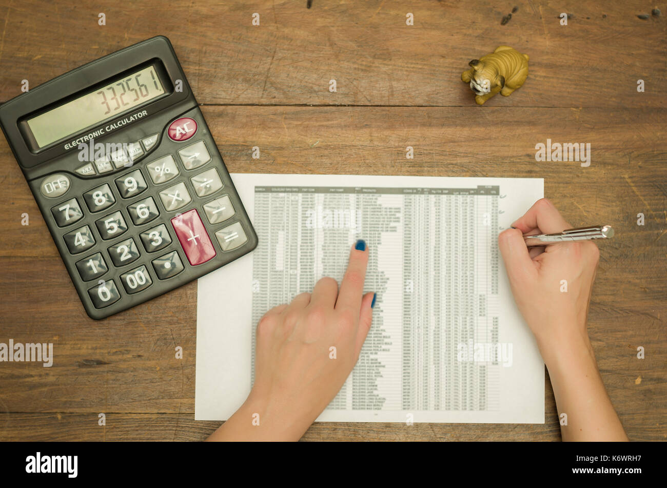 Woman hand writing on table and calculating with calculator. Table with ...