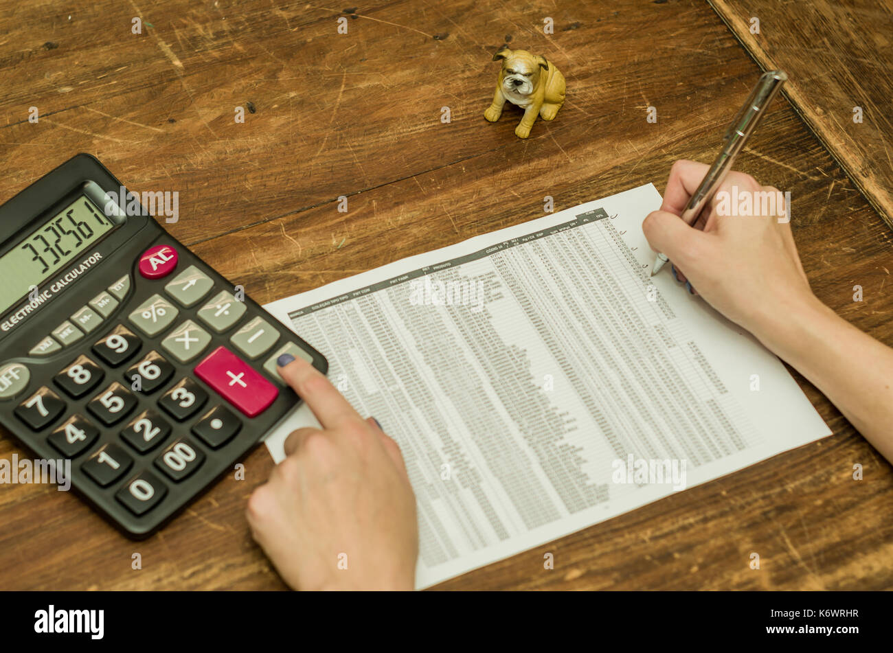 Woman hand writing on table and calculating with calculator. Table with ...