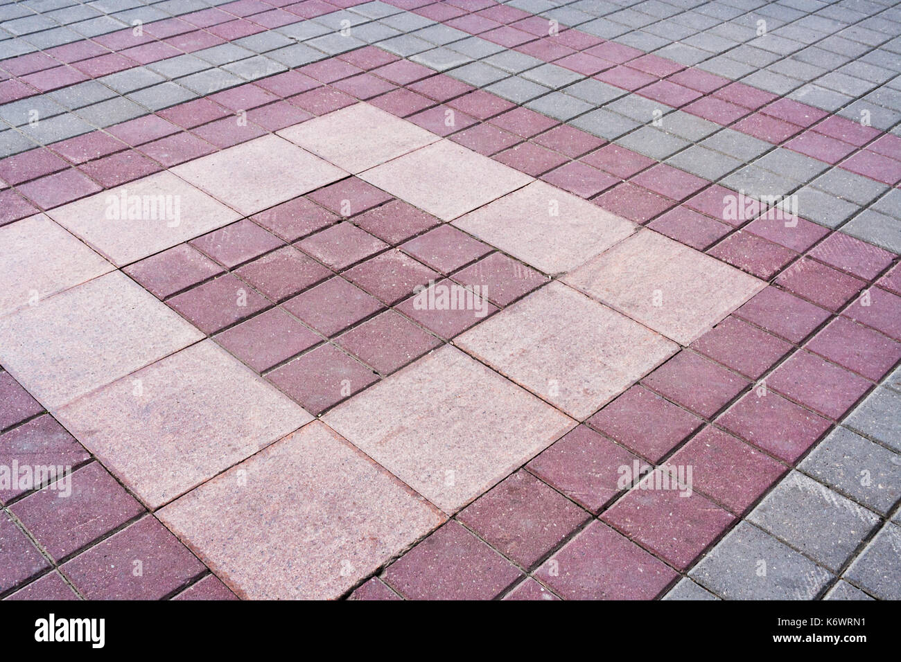Geometric pattern of tiles in different size and color on the sidewalk ...