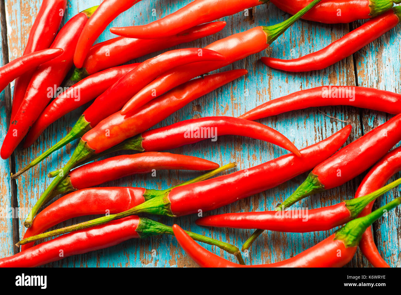 Hot red chili pepper on a old blue color wooden table with place copy ...