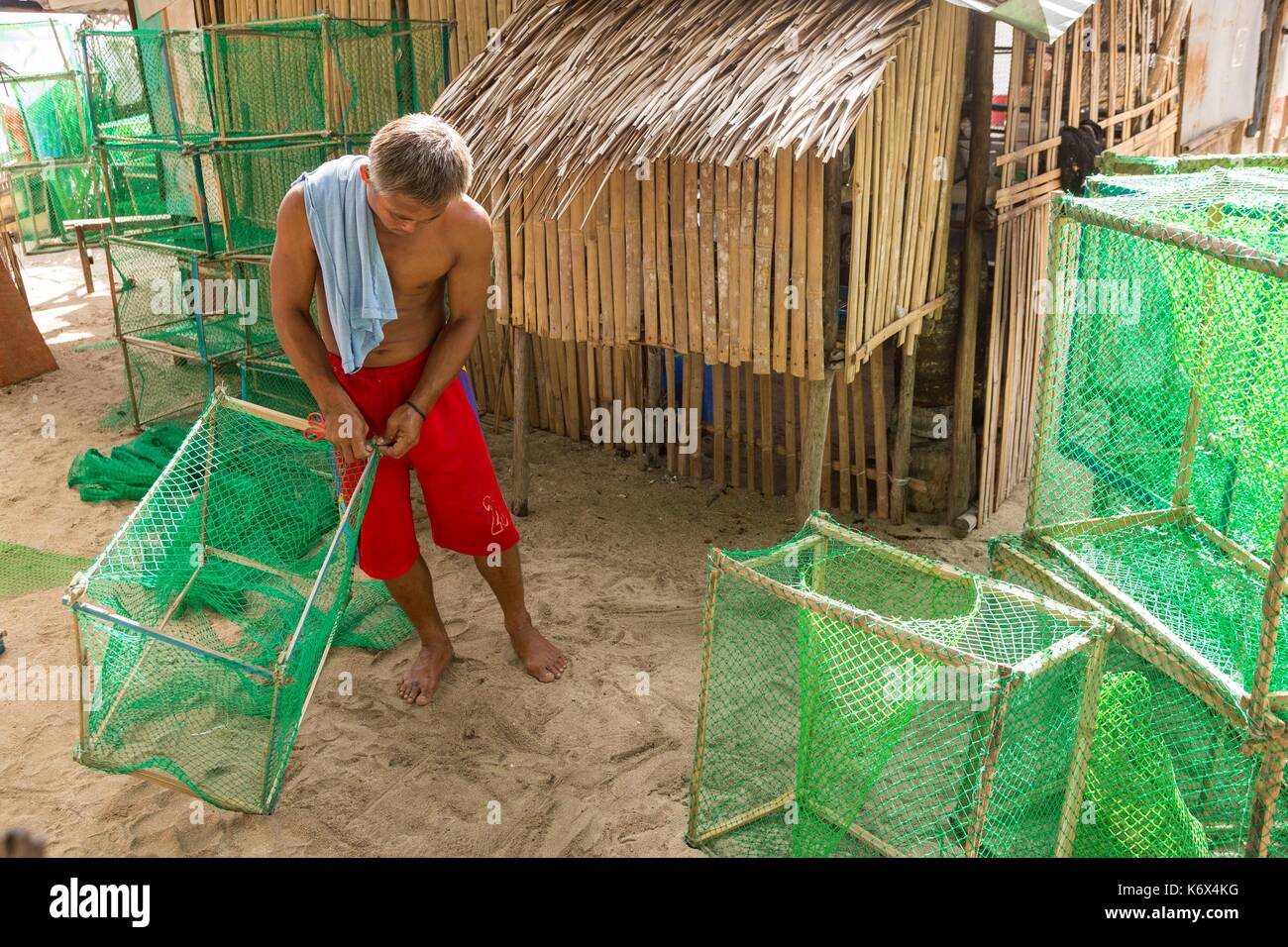 Philippines, Palawan, Aborlan, Sombrero Island, man making fish traps ...