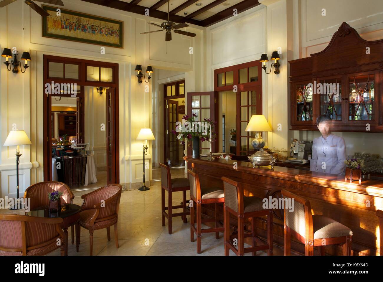 Laos, Vientiane, barman in the colonial style bar of the hotel Settha ...