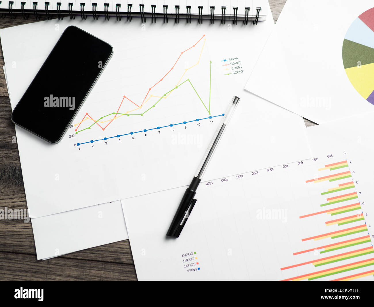 mobile phone with bar chart graph and pen Stock Photo - Alamy