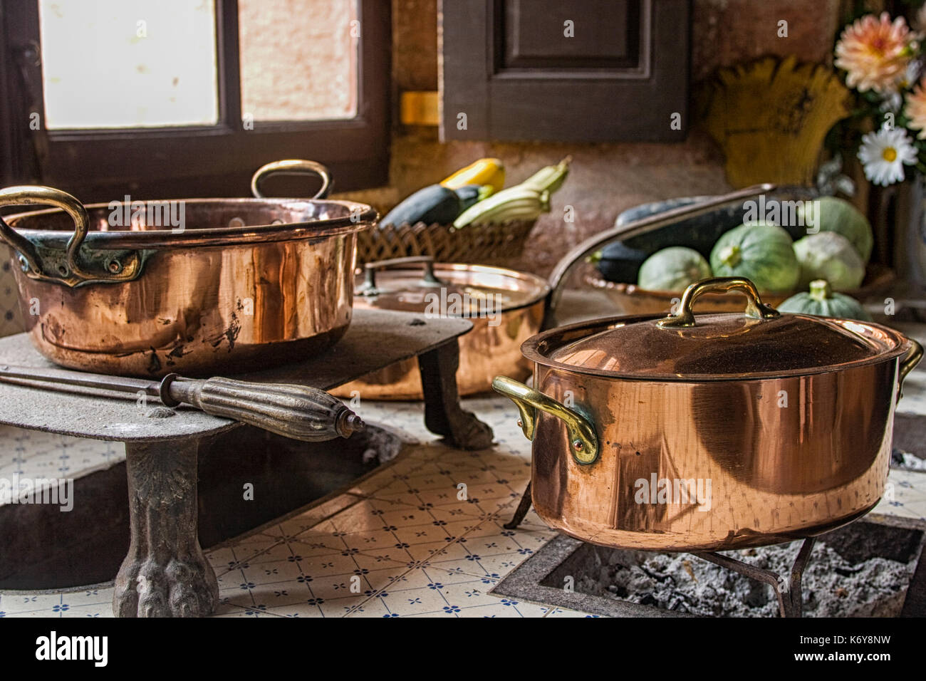 Copper pans on 17th century coal stove in preserved kitchen in an old ...