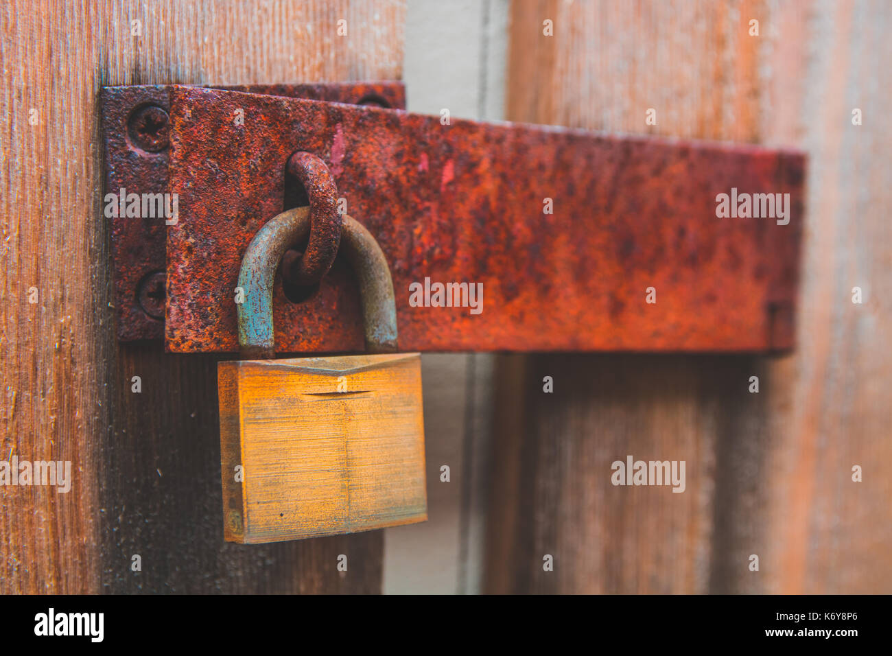 Rusty padlock on wooden door Stock Photo - Alamy