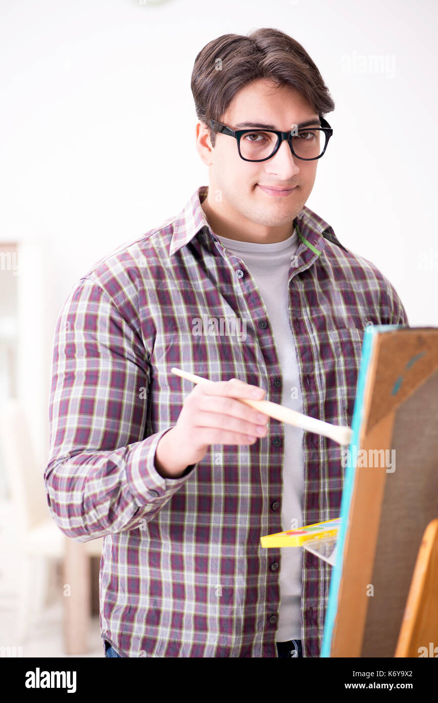 Young male artist drawing pictures in bright studio Stock Photo - Alamy
