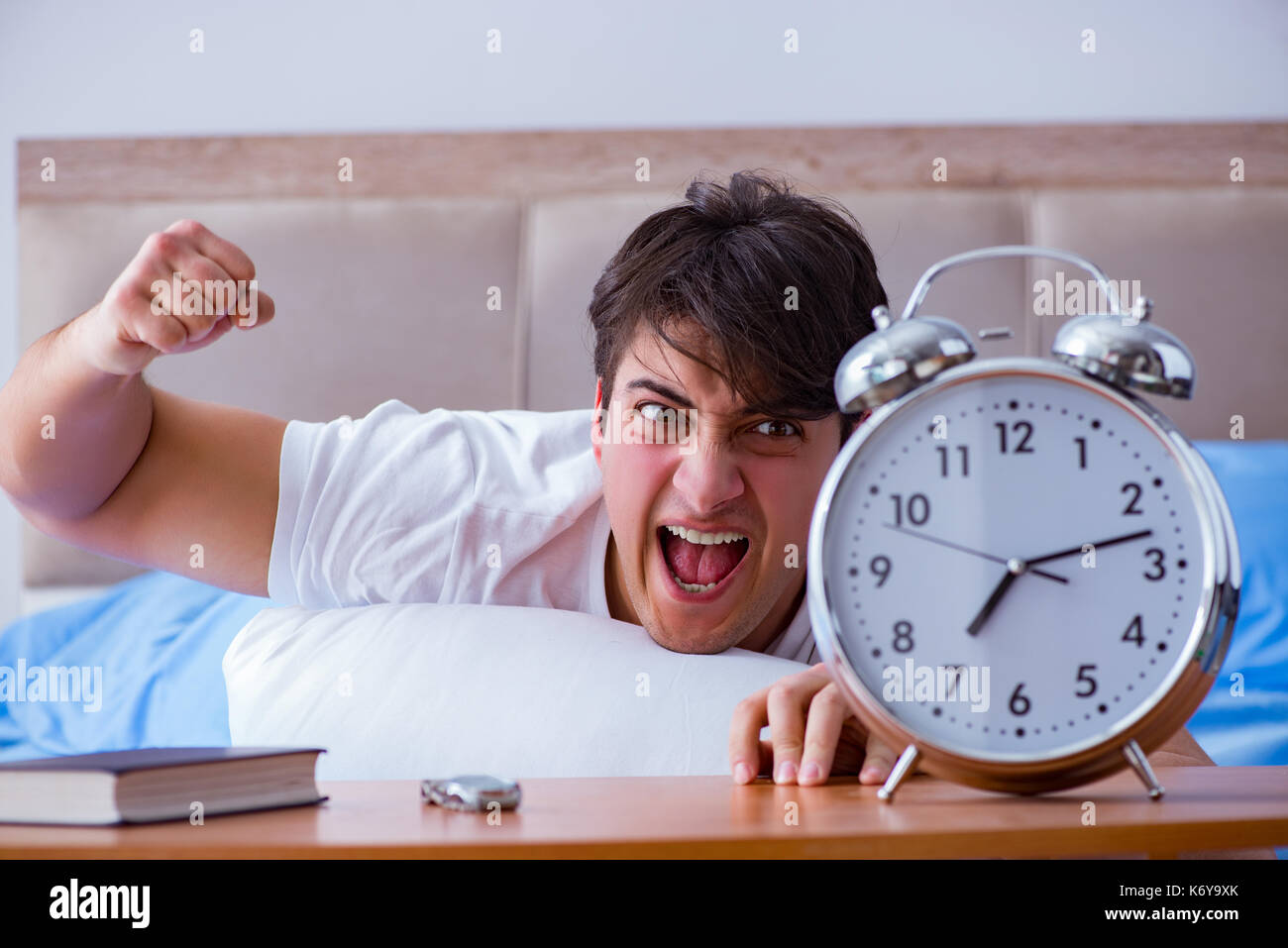 Man in bed frustrated suffering from insomnia with an alarm clock Stock ...